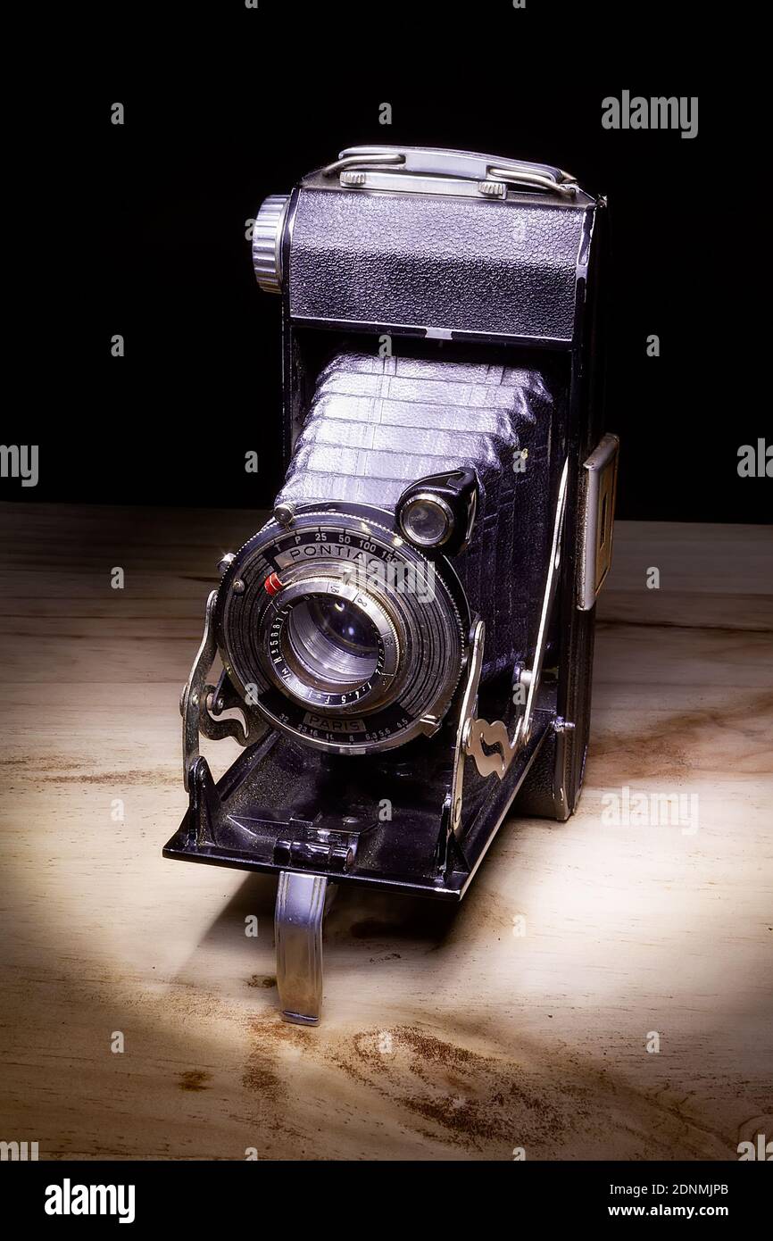 A vertical shot of a vintage camera on a wooden table Stock Photo - Alamy