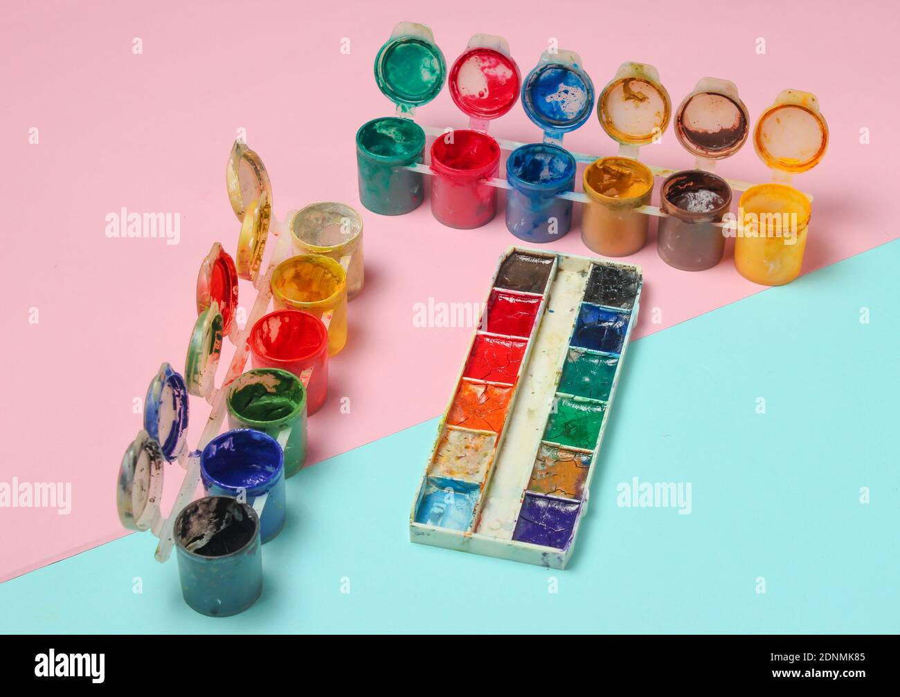 Bottles of gouache and watercolor paint for drawing on a pink blue ...