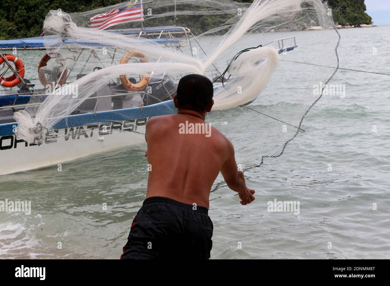 Fisher man throwing fishing net for catching fish for food Stock Photo ...