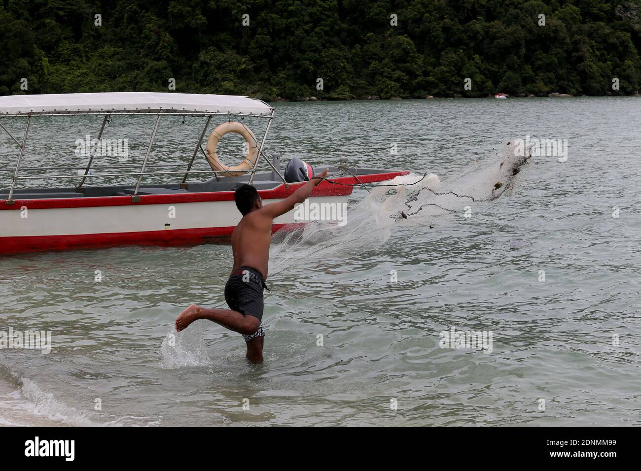 Fisher man throwing fishing net for catching fish for food Stock Photo ...