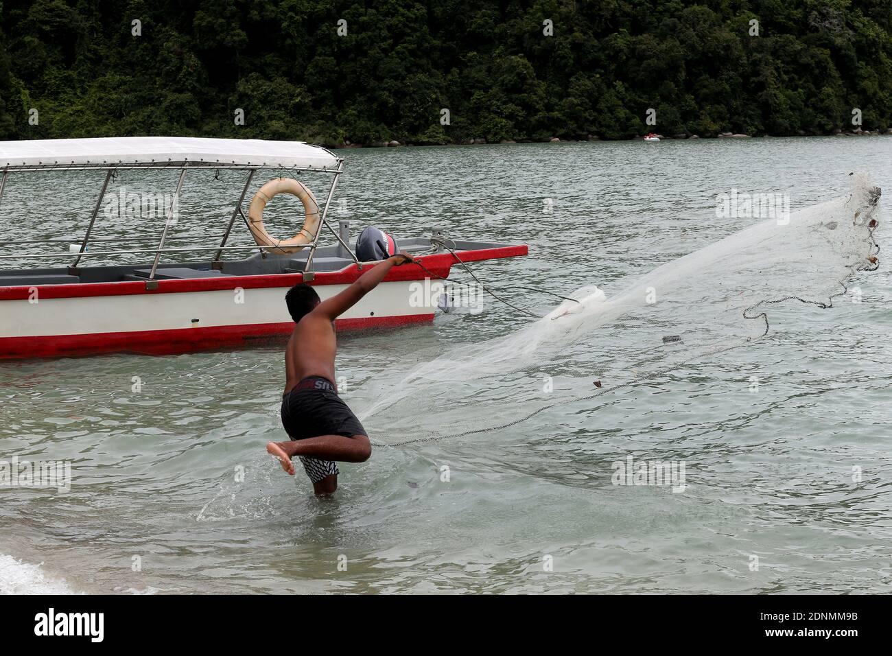 Fisher man throwing fishing net for catching fish for food Stock Photo ...