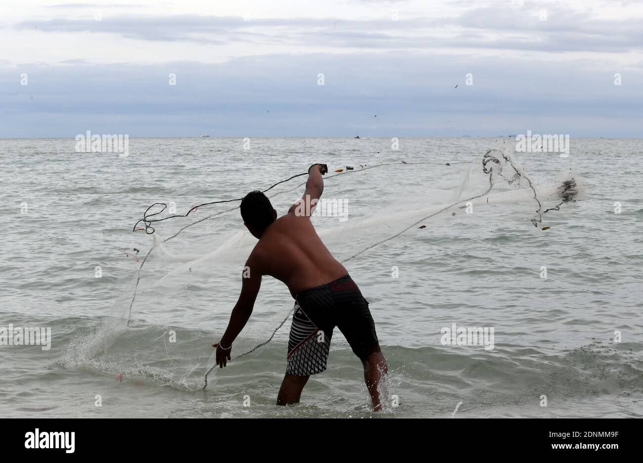 Fisher man throwing fishing net for catching fish for food Stock Photo ...