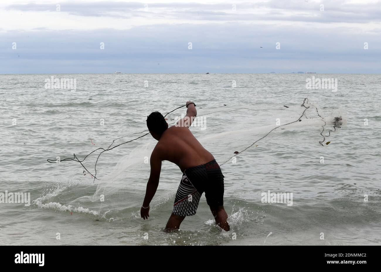 Fisher man throwing fishing net for catching fish for food Stock Photo ...