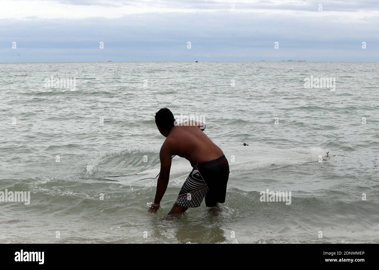 Fisher man throwing fishing net for catching fish for food Stock Photo ...