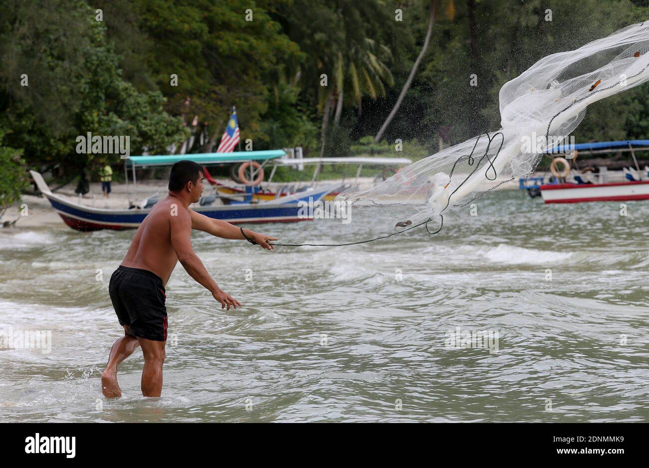 Fisher man throwing fishing net for catching fish for food Stock Photo ...