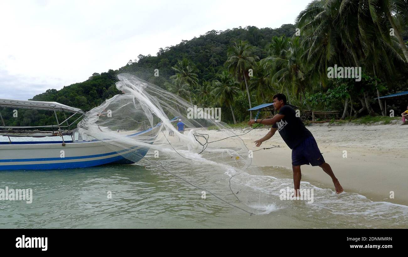 Fisher man throwing fishing net for catching fish for food Stock Photo ...