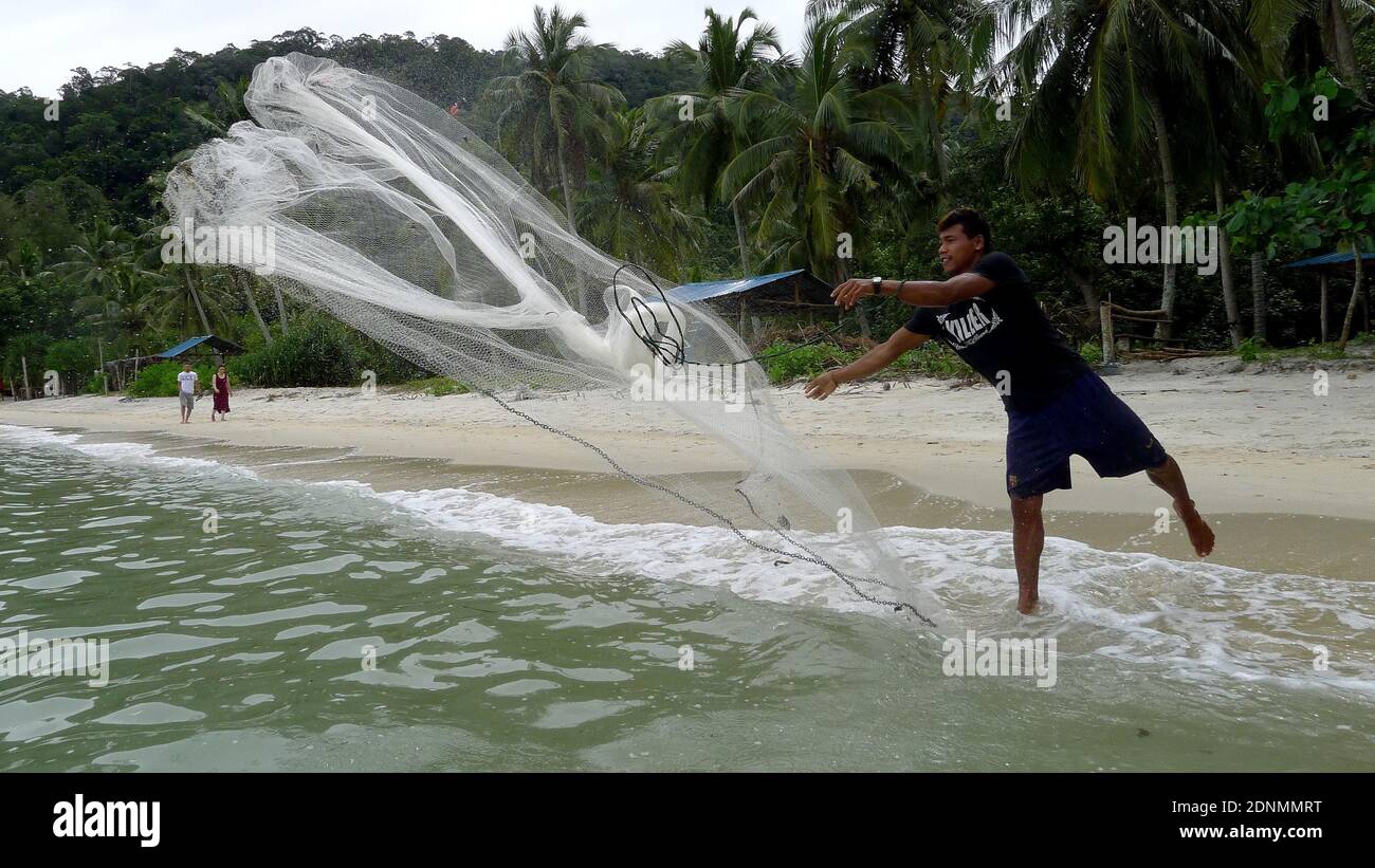 Fisher man throwing fishing net for catching fish for food Stock Photo ...