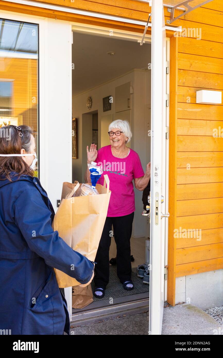Woman delivering shopping to senior woman Stock Photo - Alamy