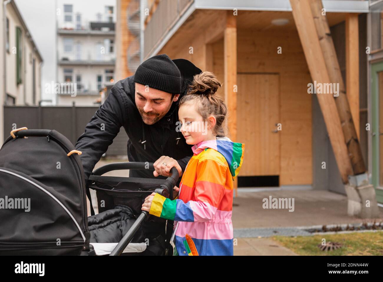 Father and daughter looking inside pram Stock Photo - Alamy