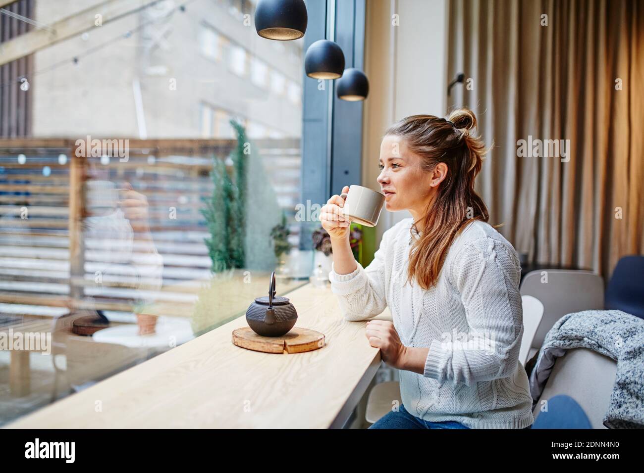 Woman looking out the window of cafe hi-res stock photography and ...