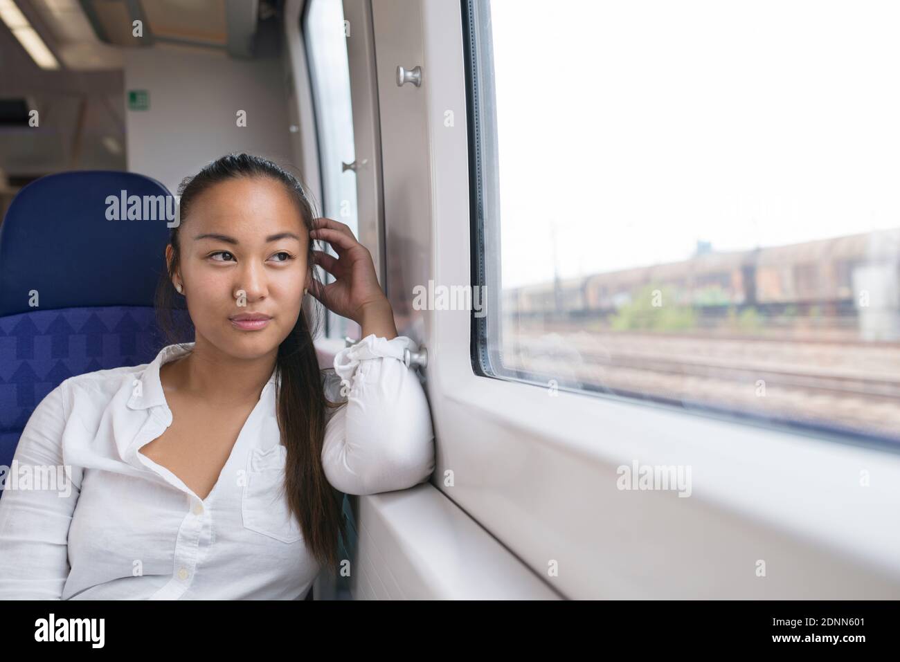 Woman in train looking through window Stock Photo - Alamy