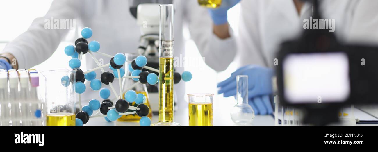 Scientists at work table on which flasks and molecules are filming ...