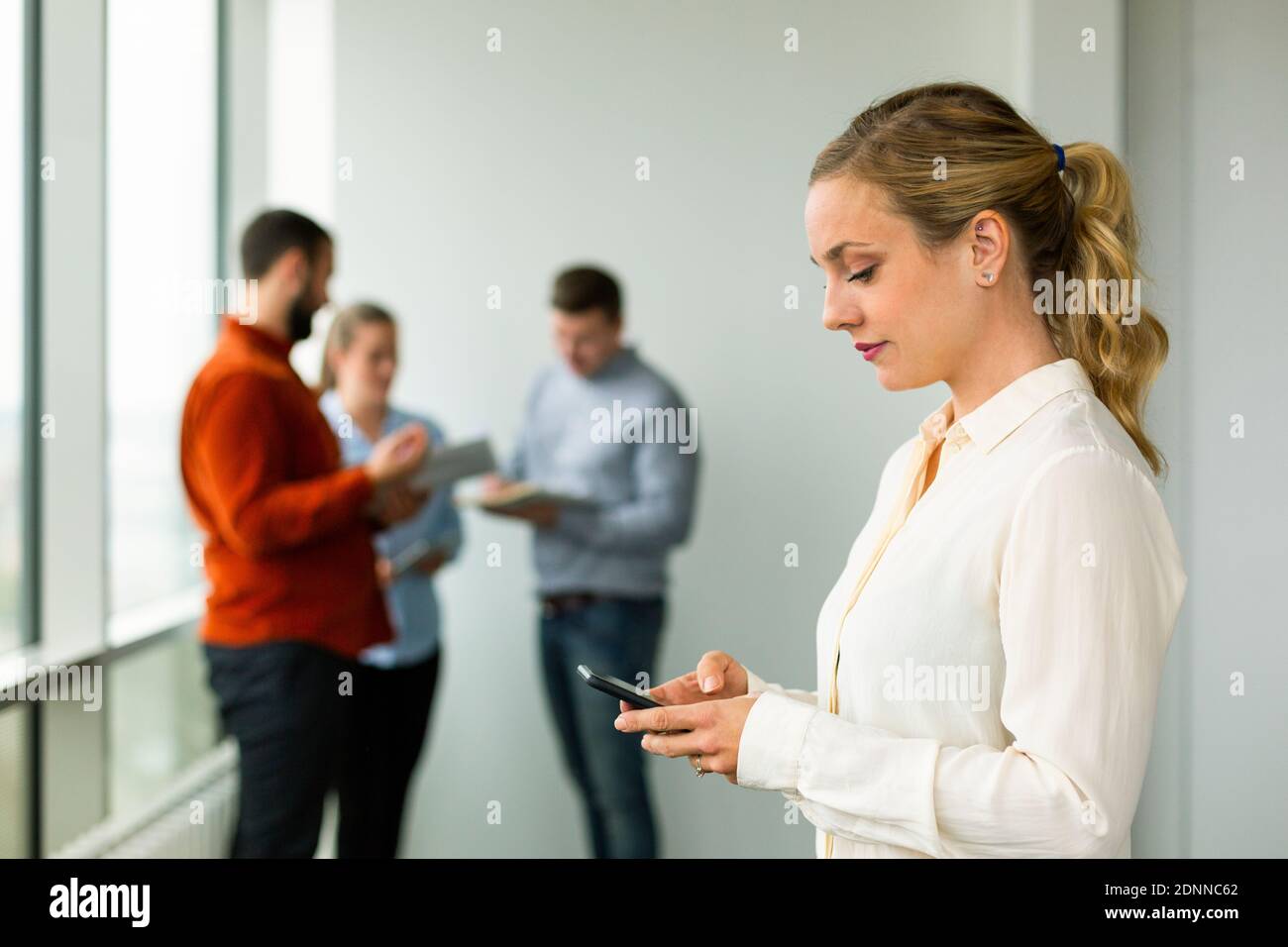 Woman at work using cell phone Stock Photo - Alamy