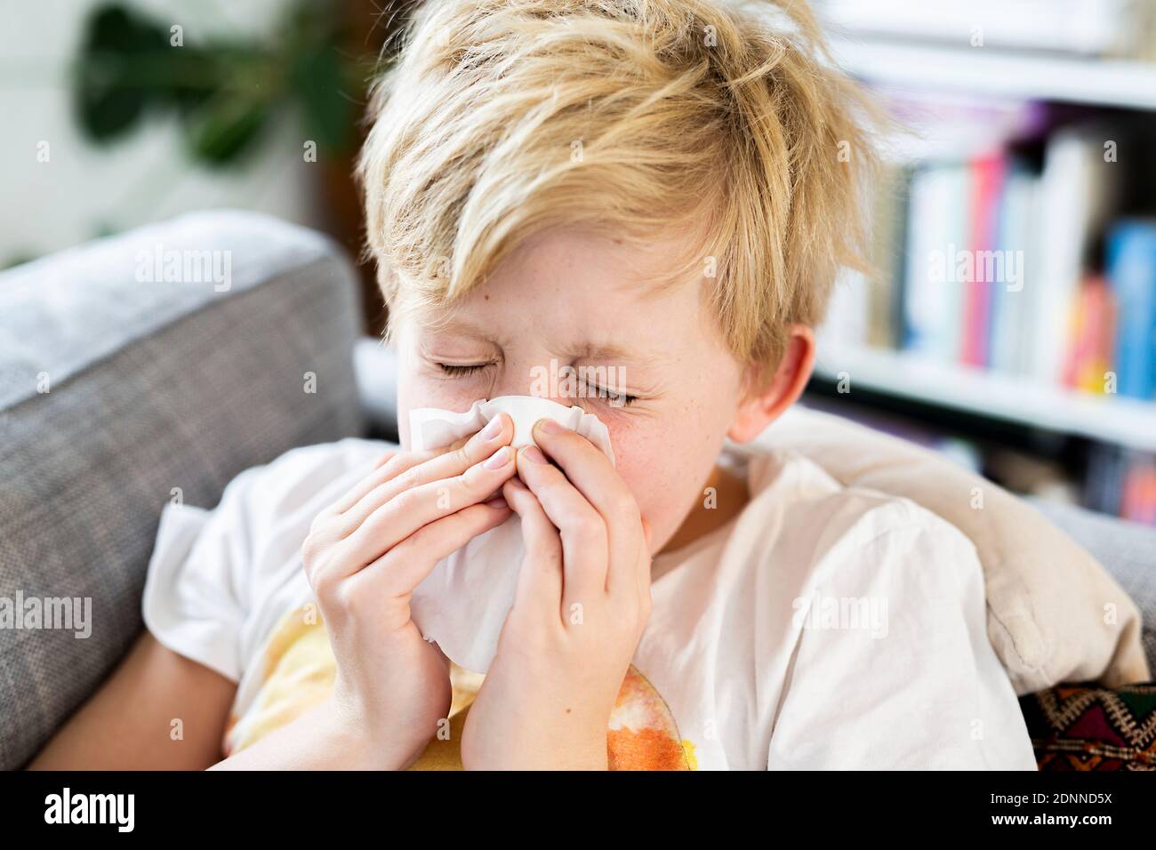 Boy sneezing Stock Photo - Alamy