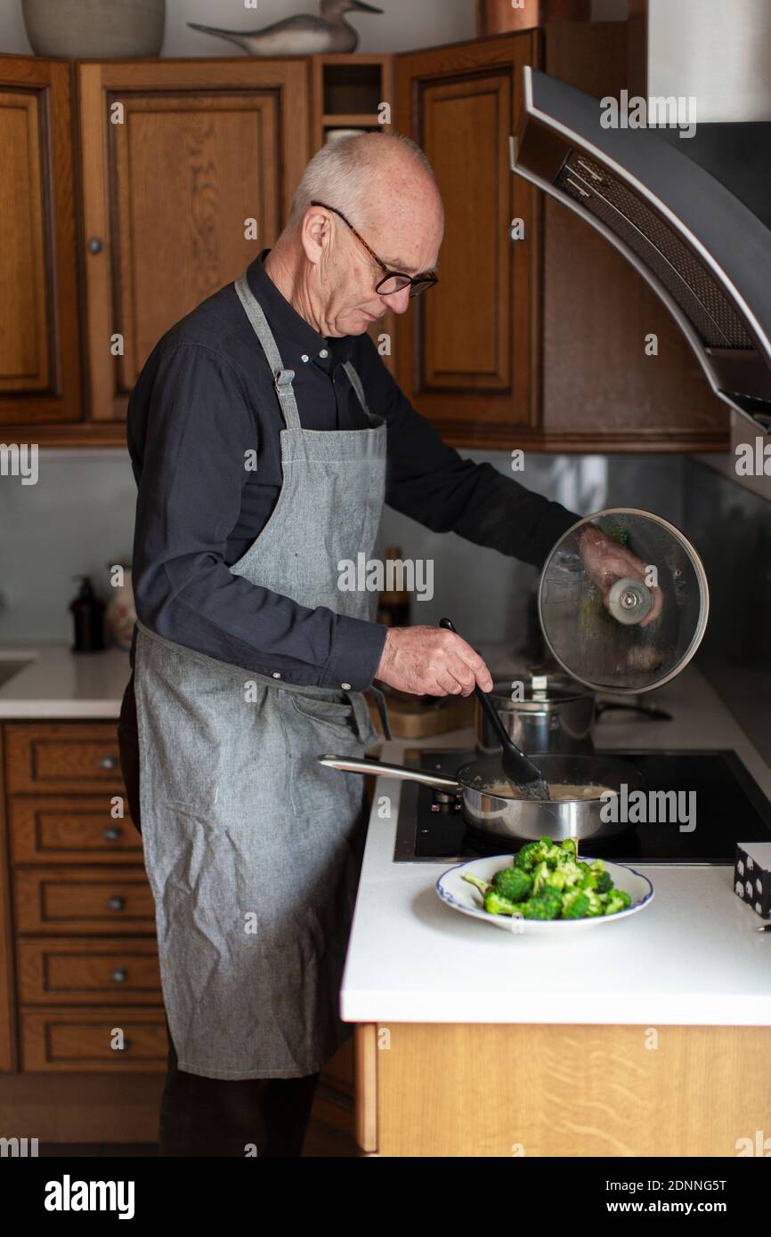 Elderly man cooking in kitchen Stock Photo - Alamy