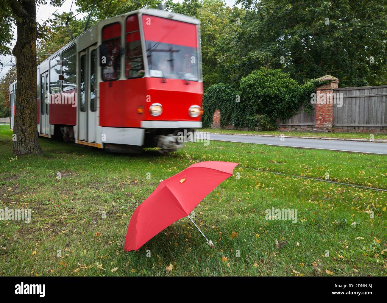 Red tram and umbrella on road in small city Stock Photo - Alamy