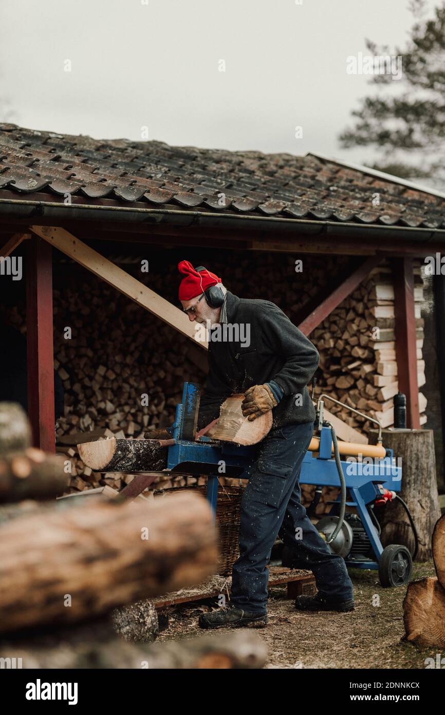 Senior man sawing wood Stock Photo - Alamy