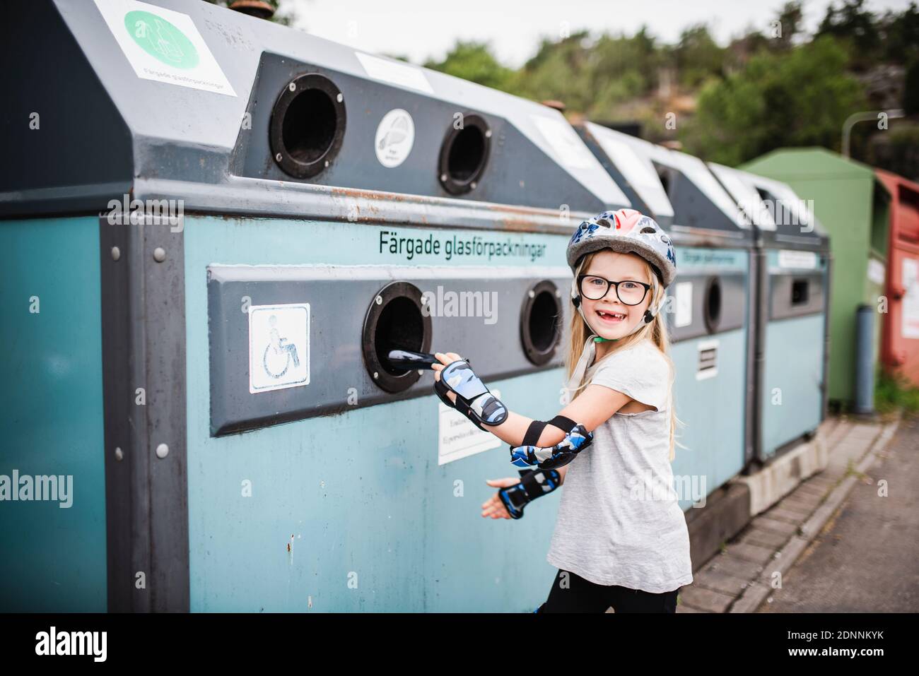 Girl putting rubbish into recycling bin Stock Photo - Alamy