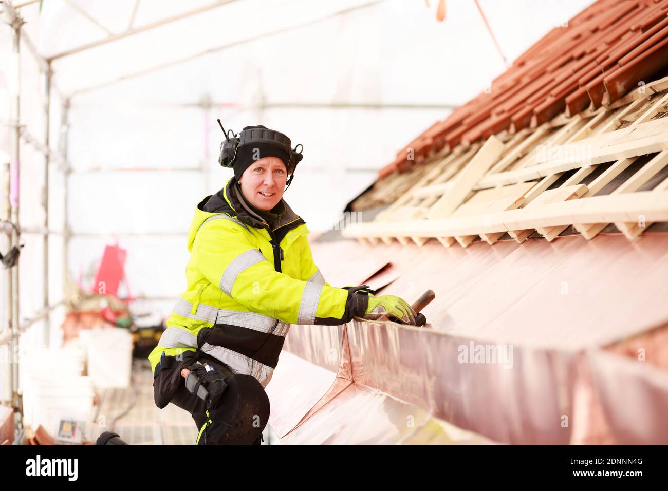 Woman working on roof Stock Photo - Alamy