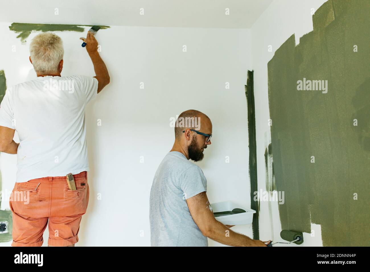 Adult man paints wall brush hi-res stock photography and images - Alamy