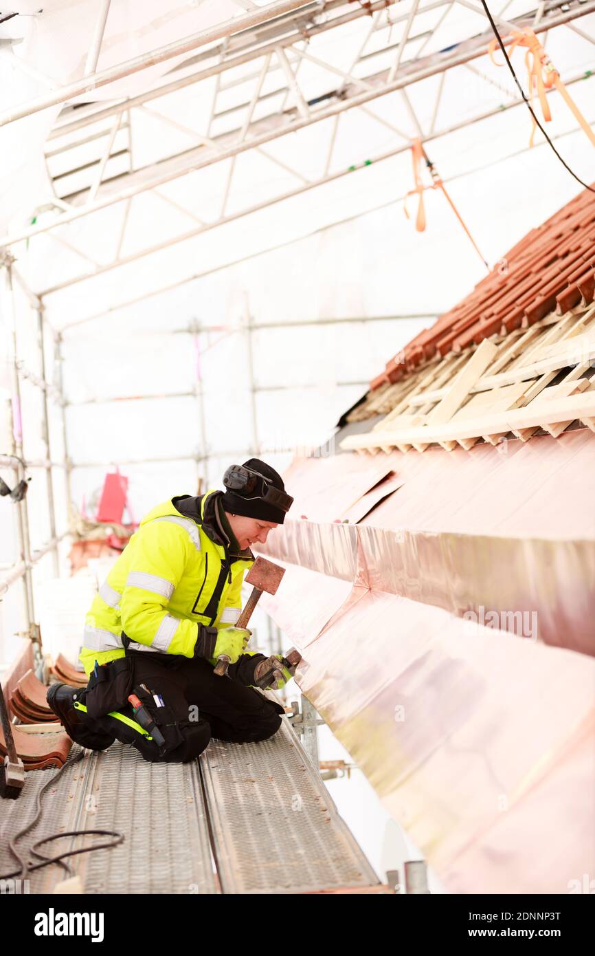 Woman working on roof Stock Photo - Alamy