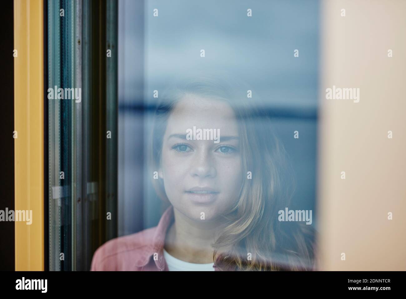 Woman looking through window Stock Photo - Alamy