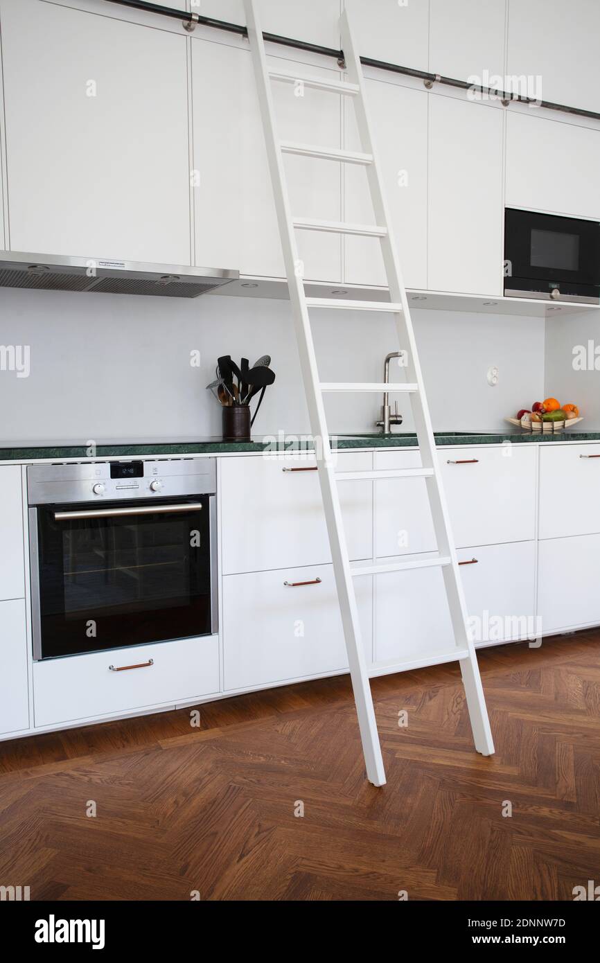 Ladder against cupboards in kitchen Stock Photo - Alamy