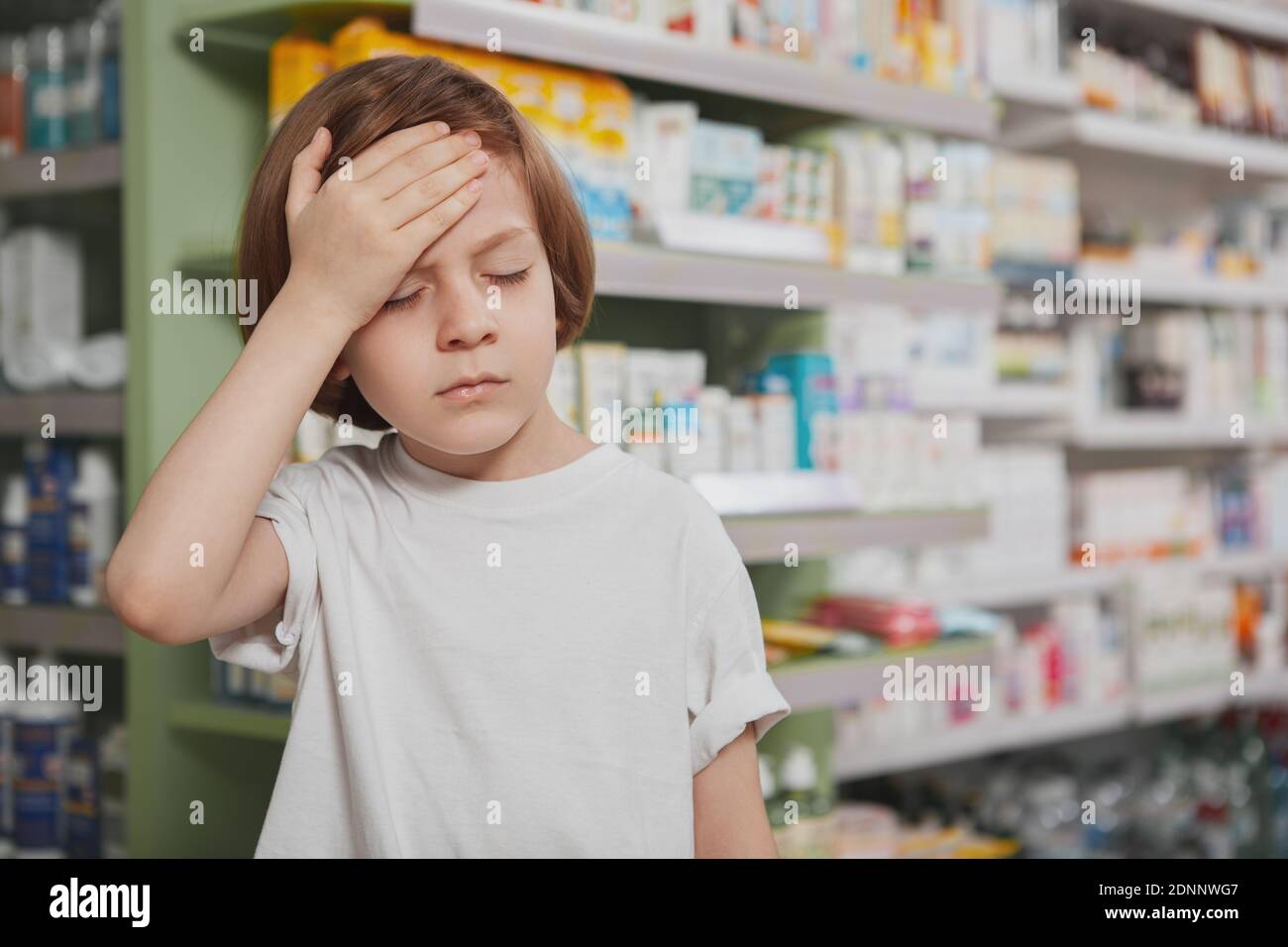 Little boy having fever at the drugstore. Little sick child having ...