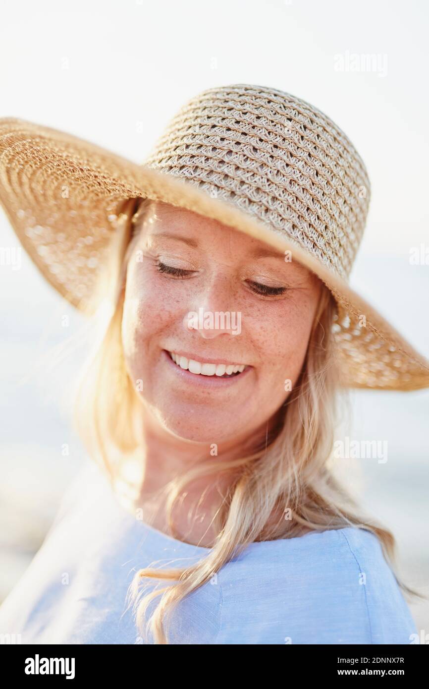 Woman wearing straw hat on beach Stock Photo - Alamy