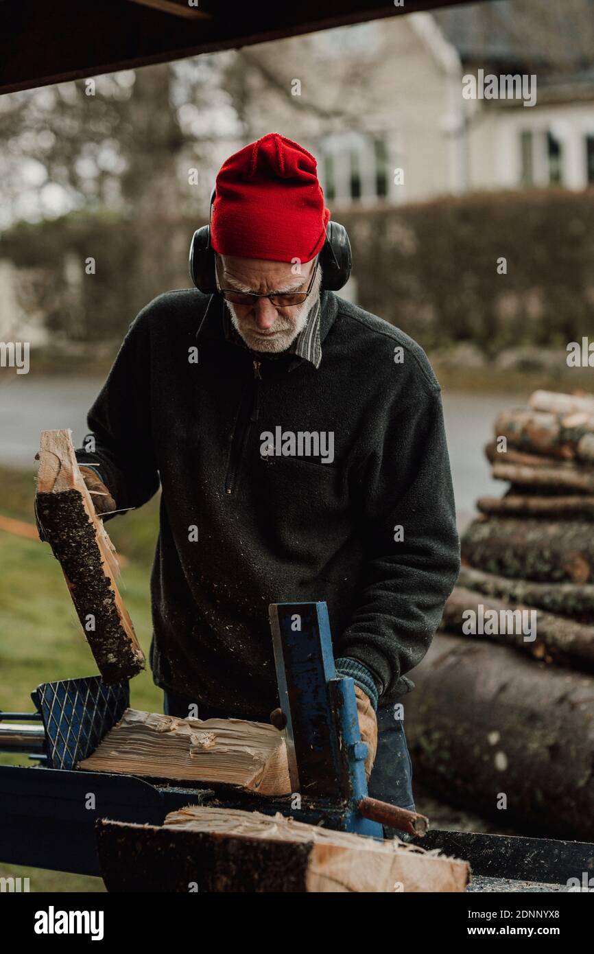 Senior man sawing wood Stock Photo - Alamy