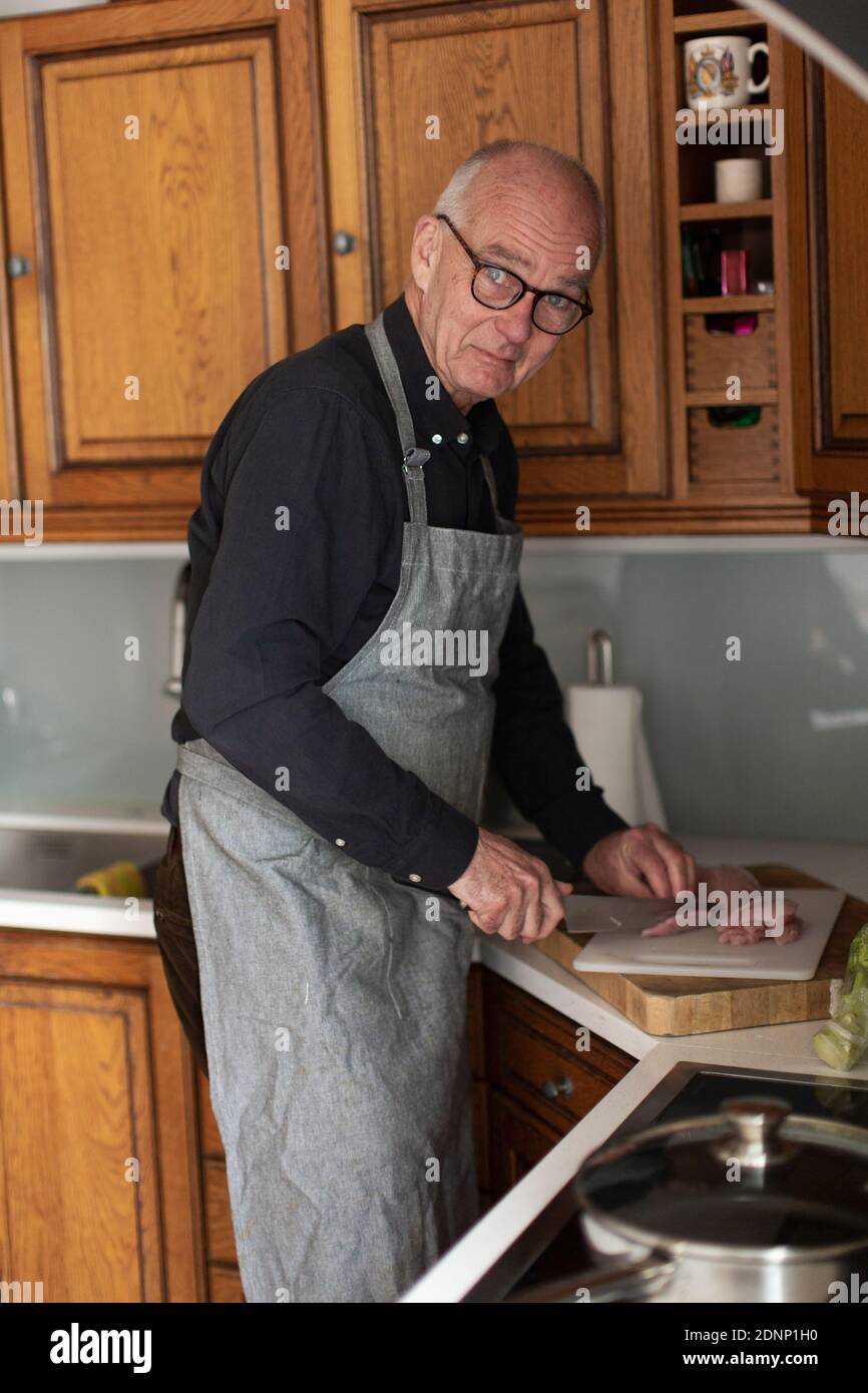 Elderly man preparing food in kitchen Stock Photo - Alamy