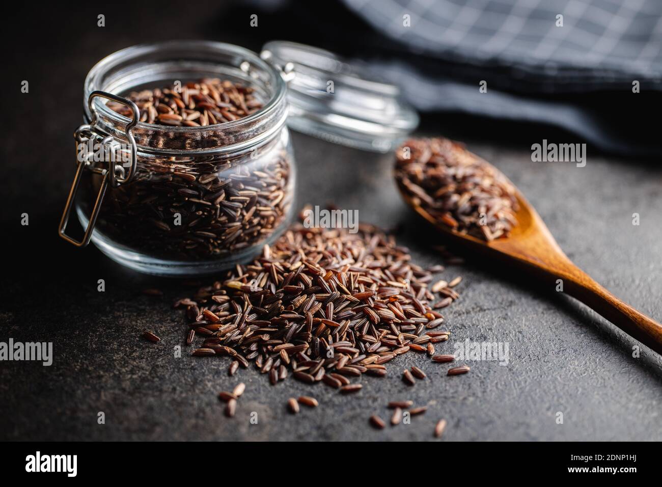 Uncooked red rice. Raw wild rice on black table Stock Photo - Alamy