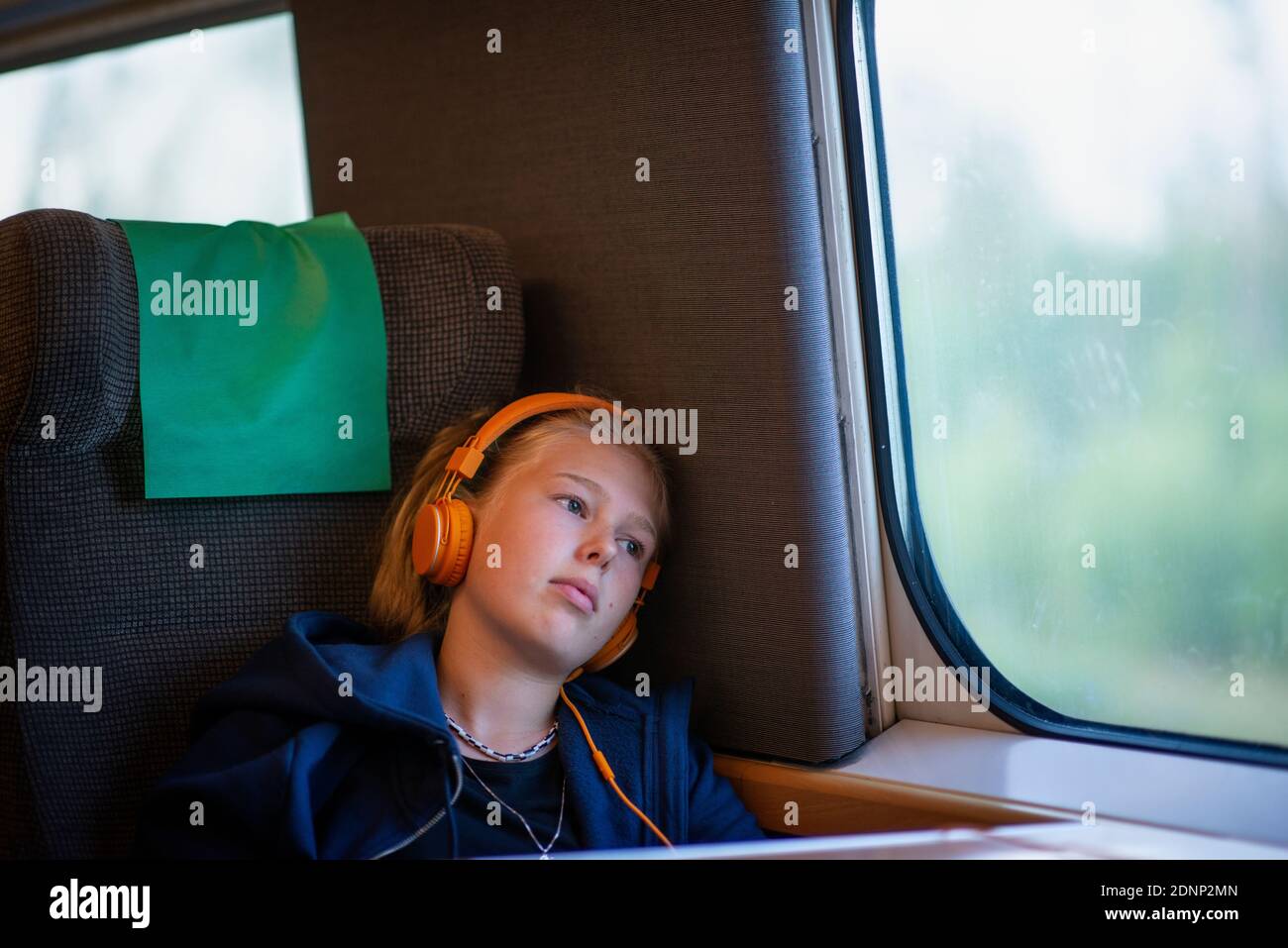 Girl in train wearing headphones Stock Photo - Alamy