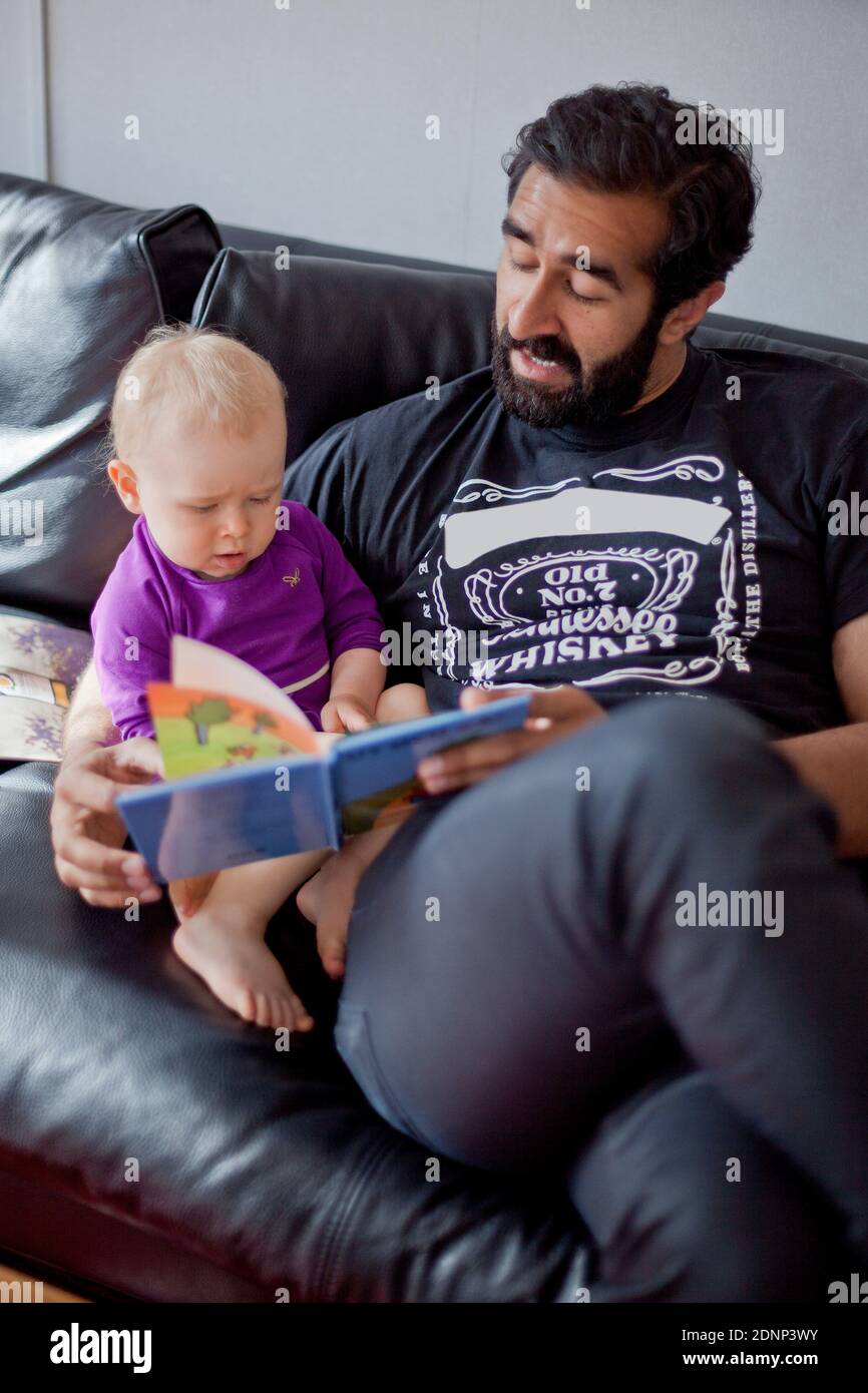 Father reading book to baby girl Stock Photo - Alamy