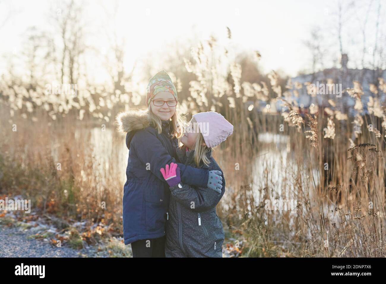 Smiling sisters standing together Stock Photo - Alamy