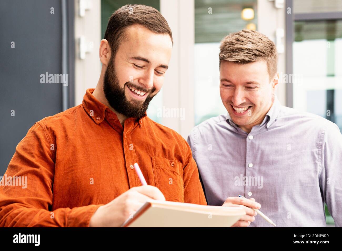 Smiling coworkers talking together Stock Photo - Alamy