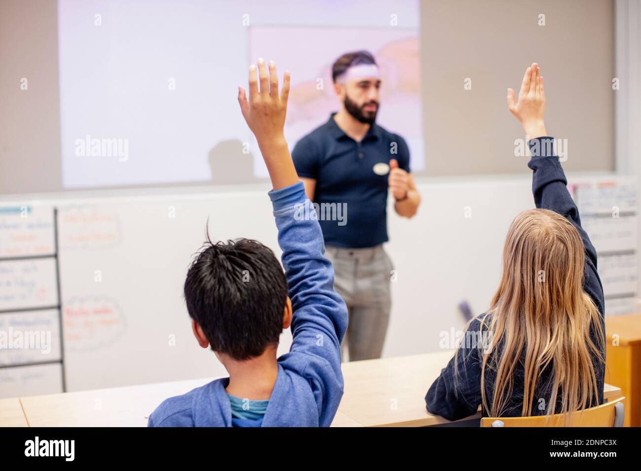Classroom raising their hands hi-res stock photography and images - Alamy