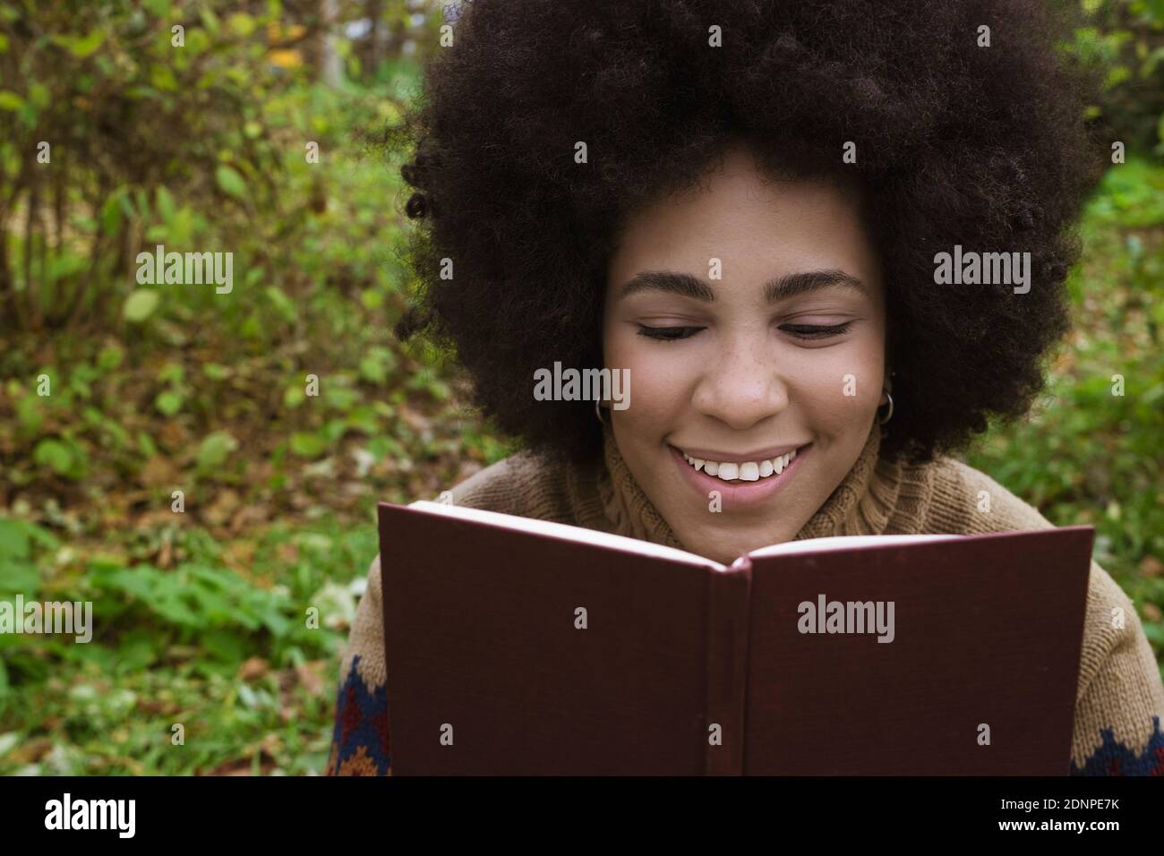 A Cuban girl enjoying reading in the park Stock Photo - Alamy
