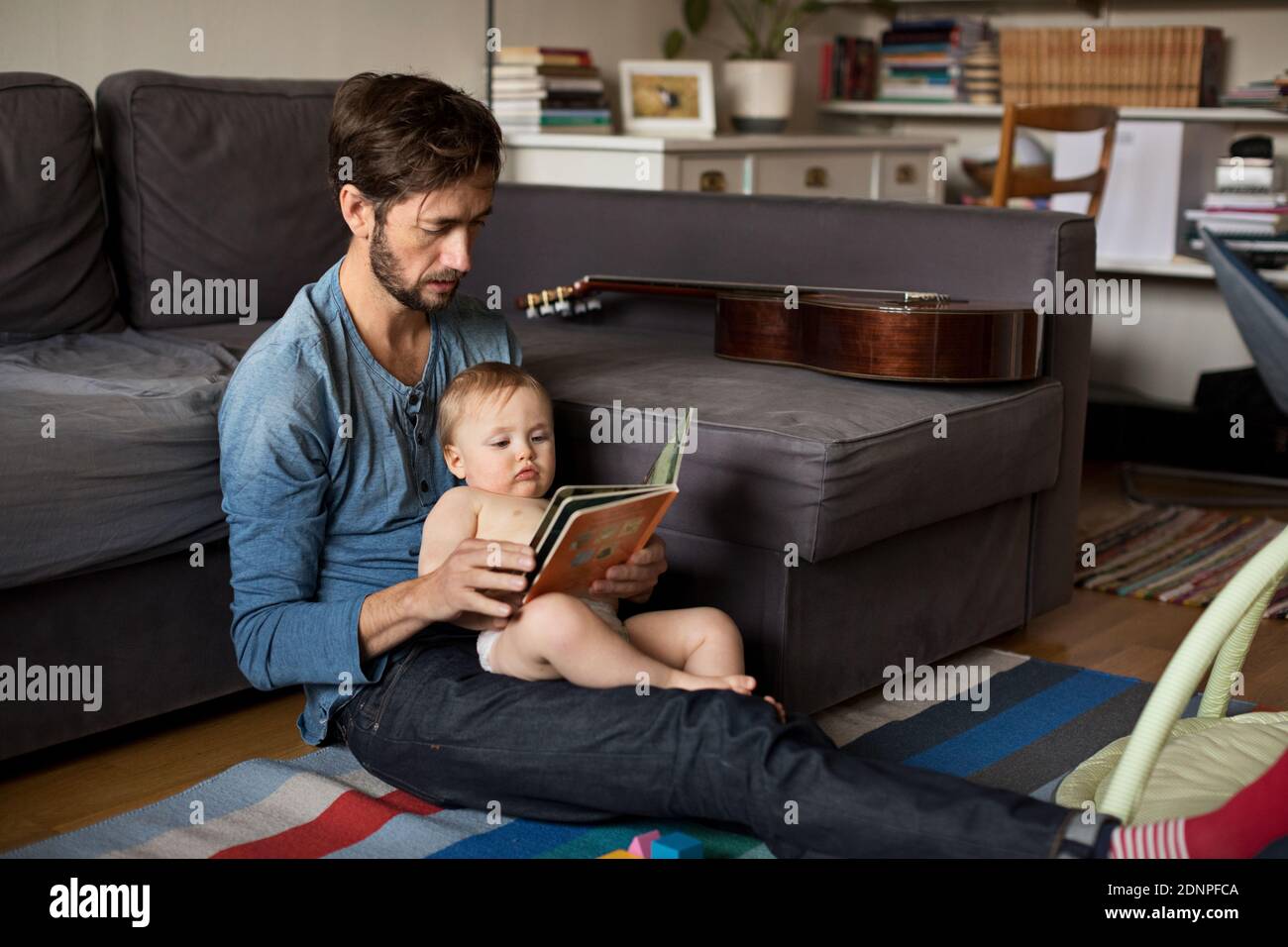 Father reading book to baby Stock Photo - Alamy