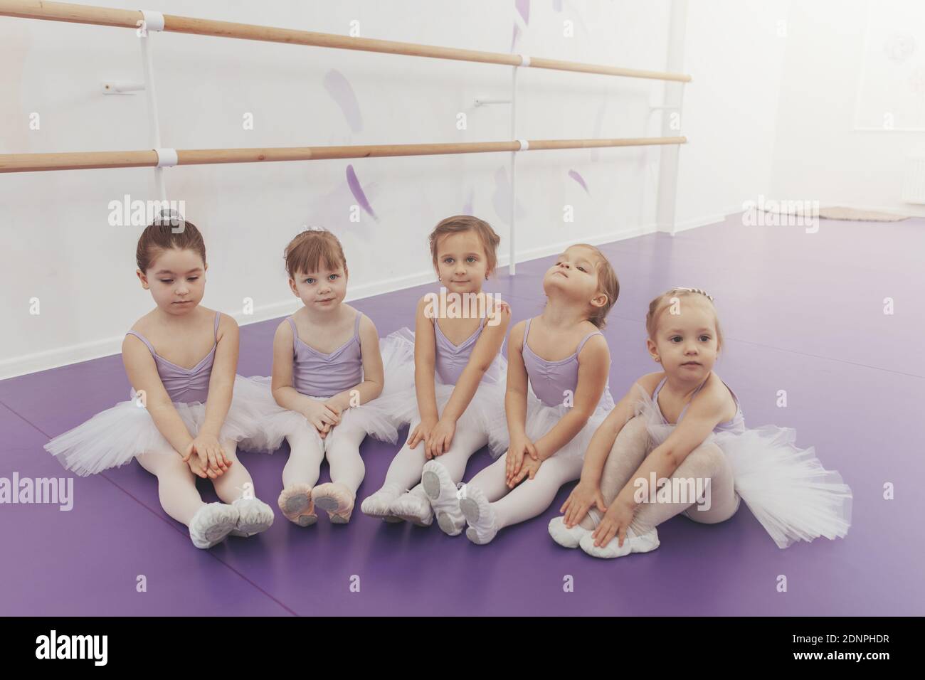 Cute little girls sitting on the floor, resting after ballet lesson at ...