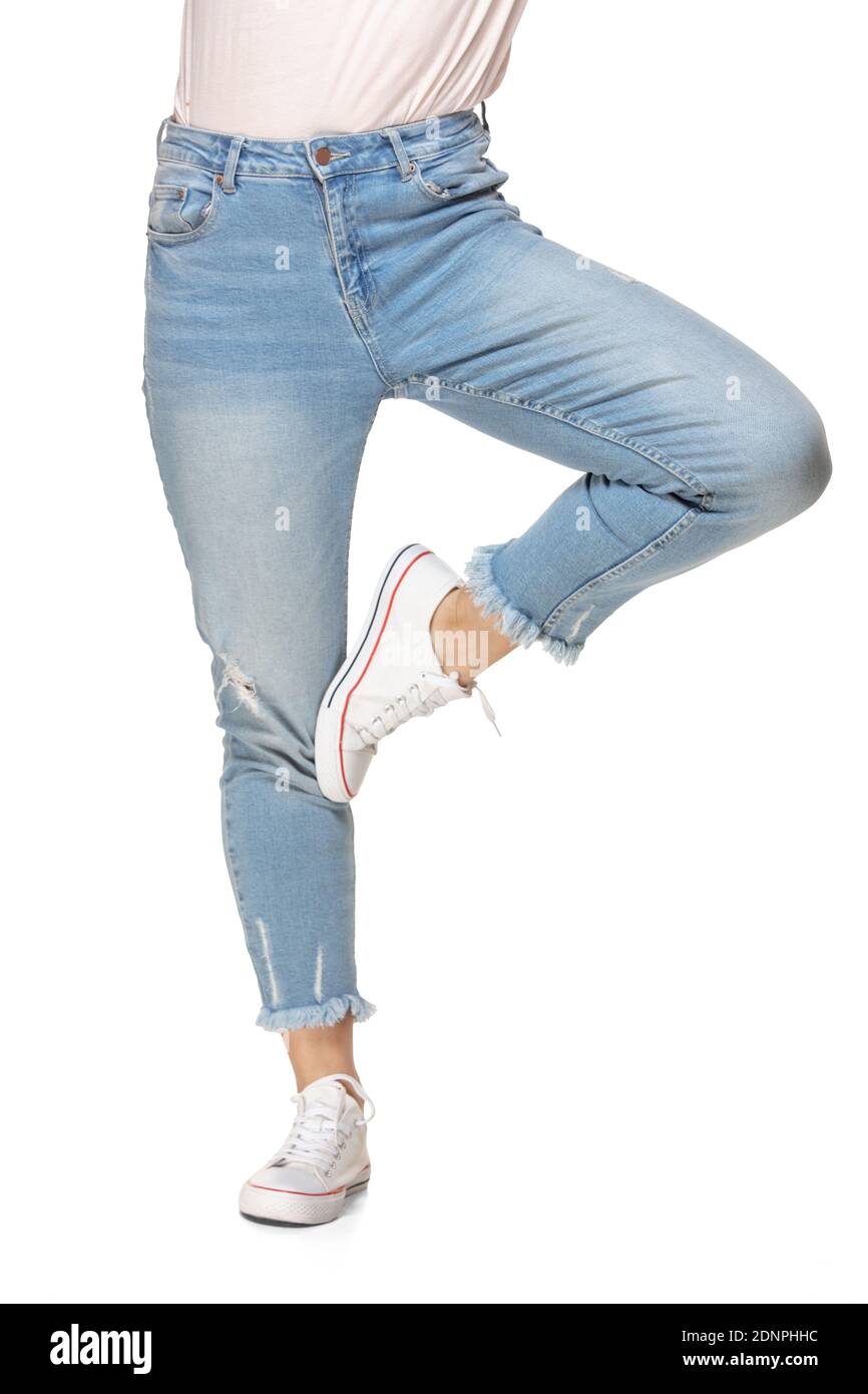 Beautiful female legs in blue jeans and sport shoes isolated on white ...
