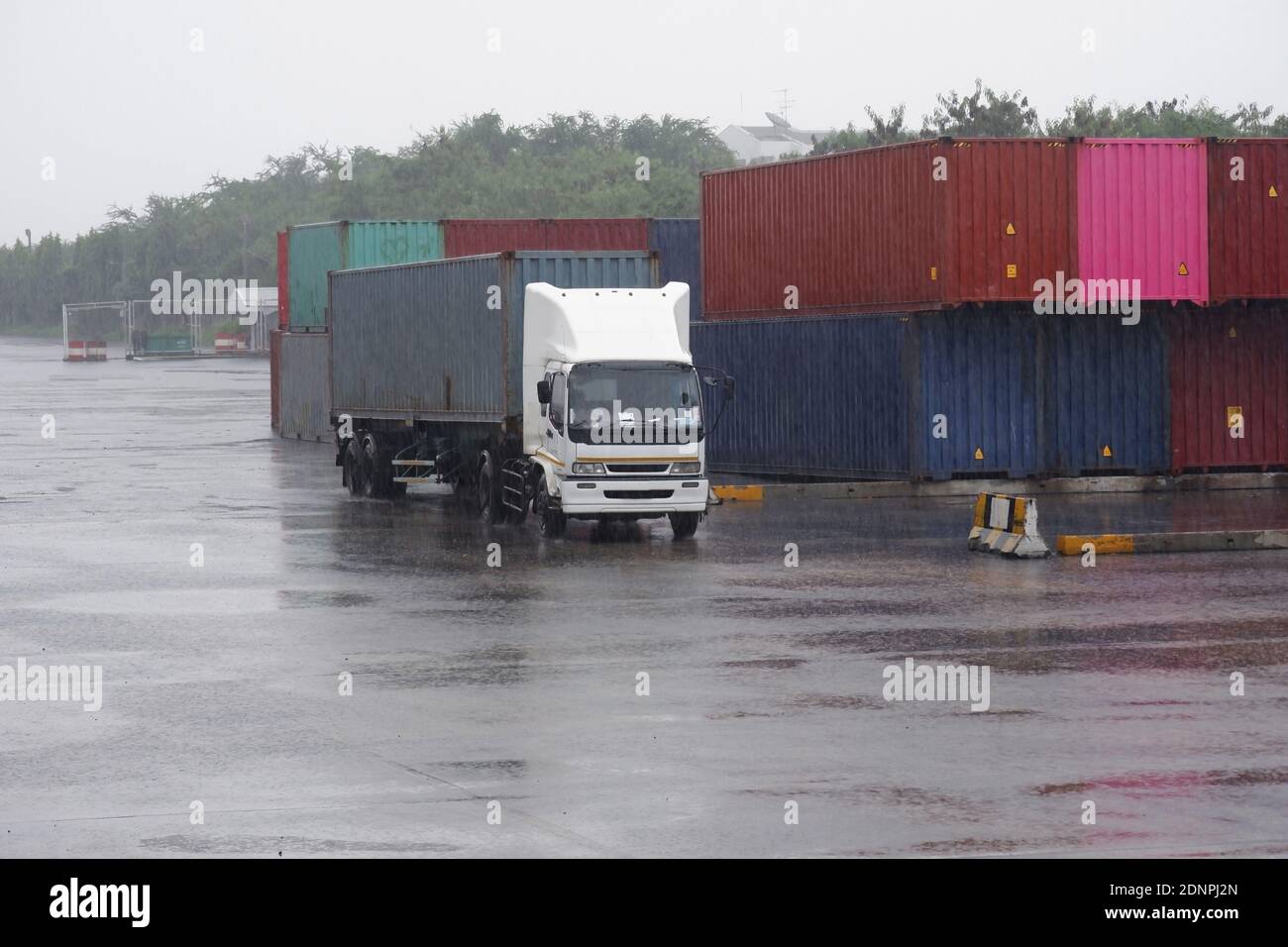 Container truck working in the rain Stock Photo - Alamy