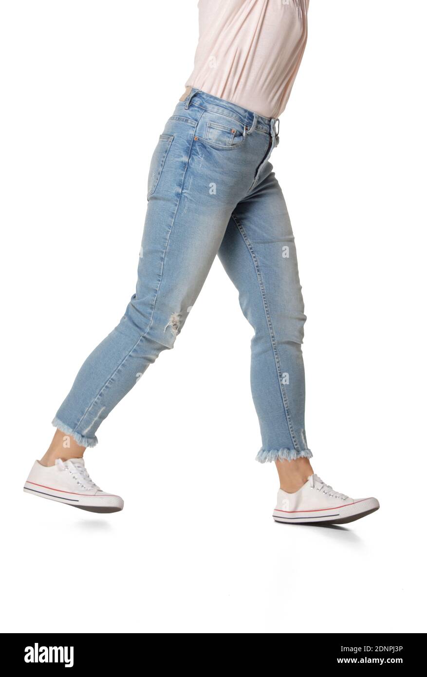 Beautiful female legs in blue jeans and sport shoes isolated on white ...