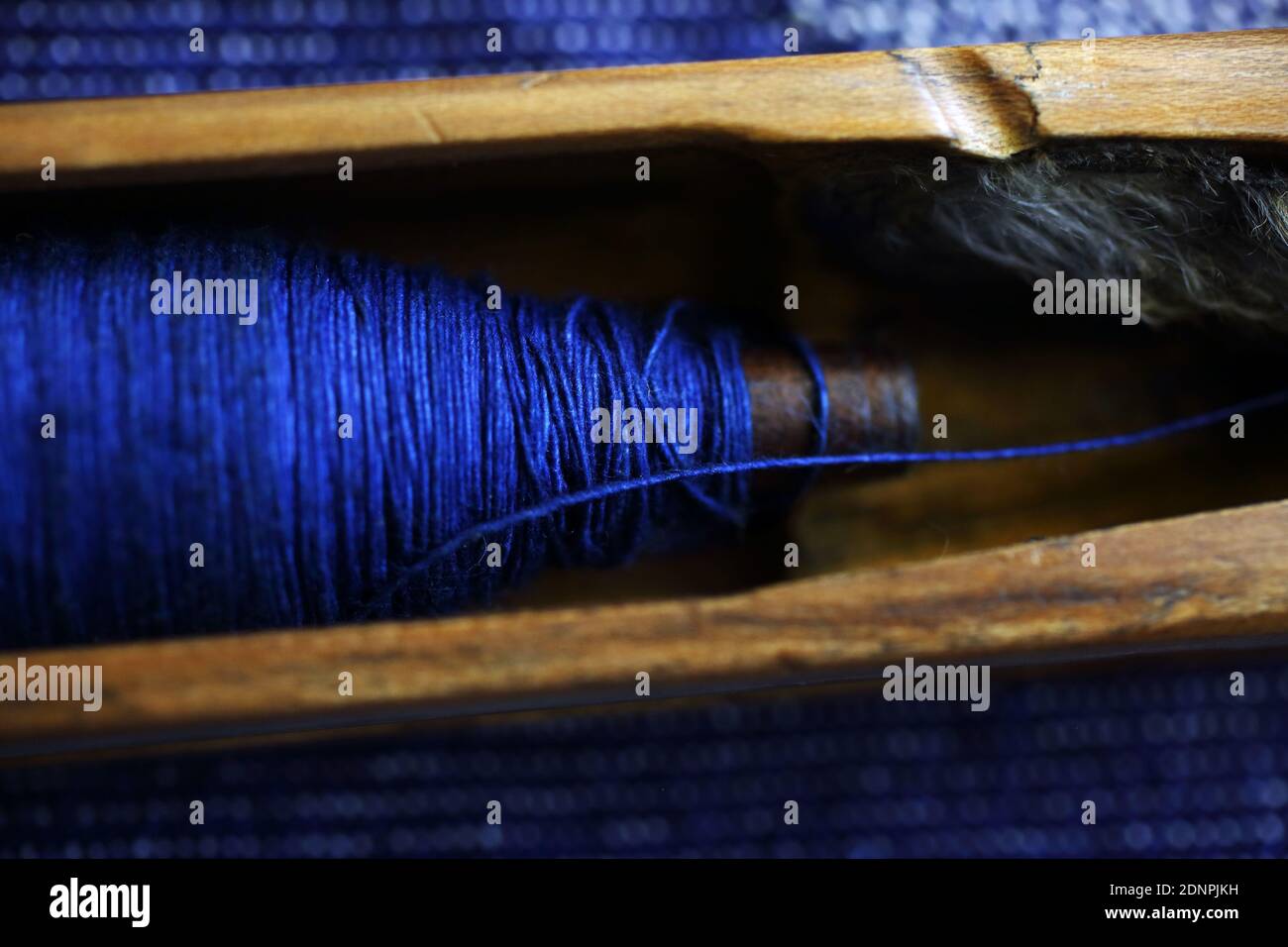 Vintage weaving loom shuttle with blue thread on denim Stock Photo - Alamy