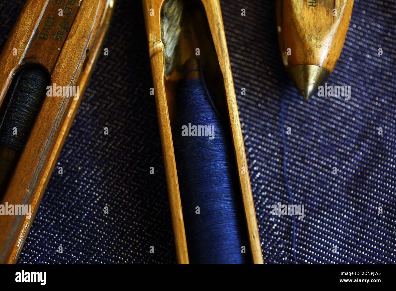 Vintage weaving loom shuttle with blue thread on denim Stock Photo - Alamy
