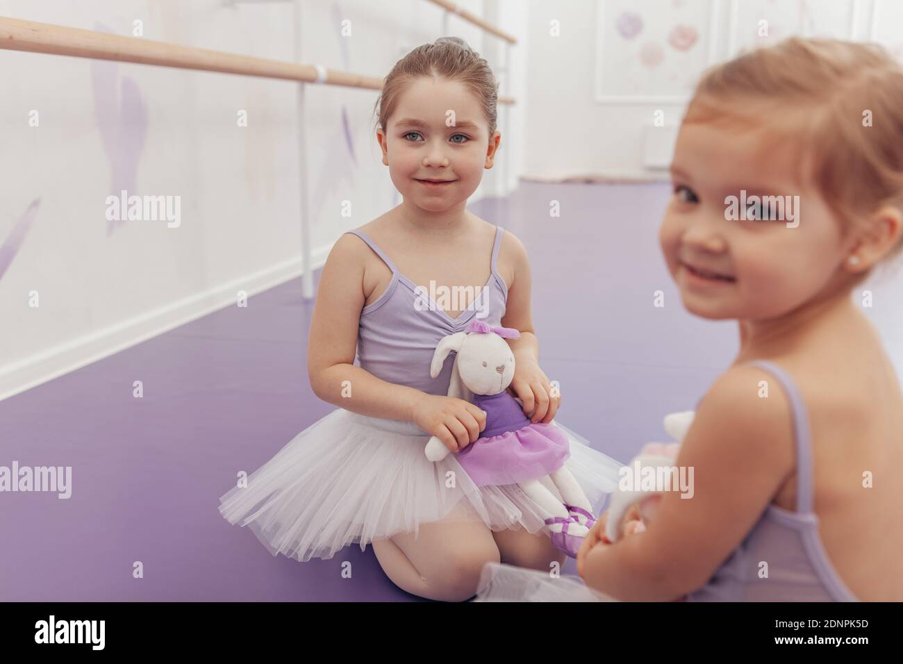 Cute little ballerinas sitting together at dance school before the ...