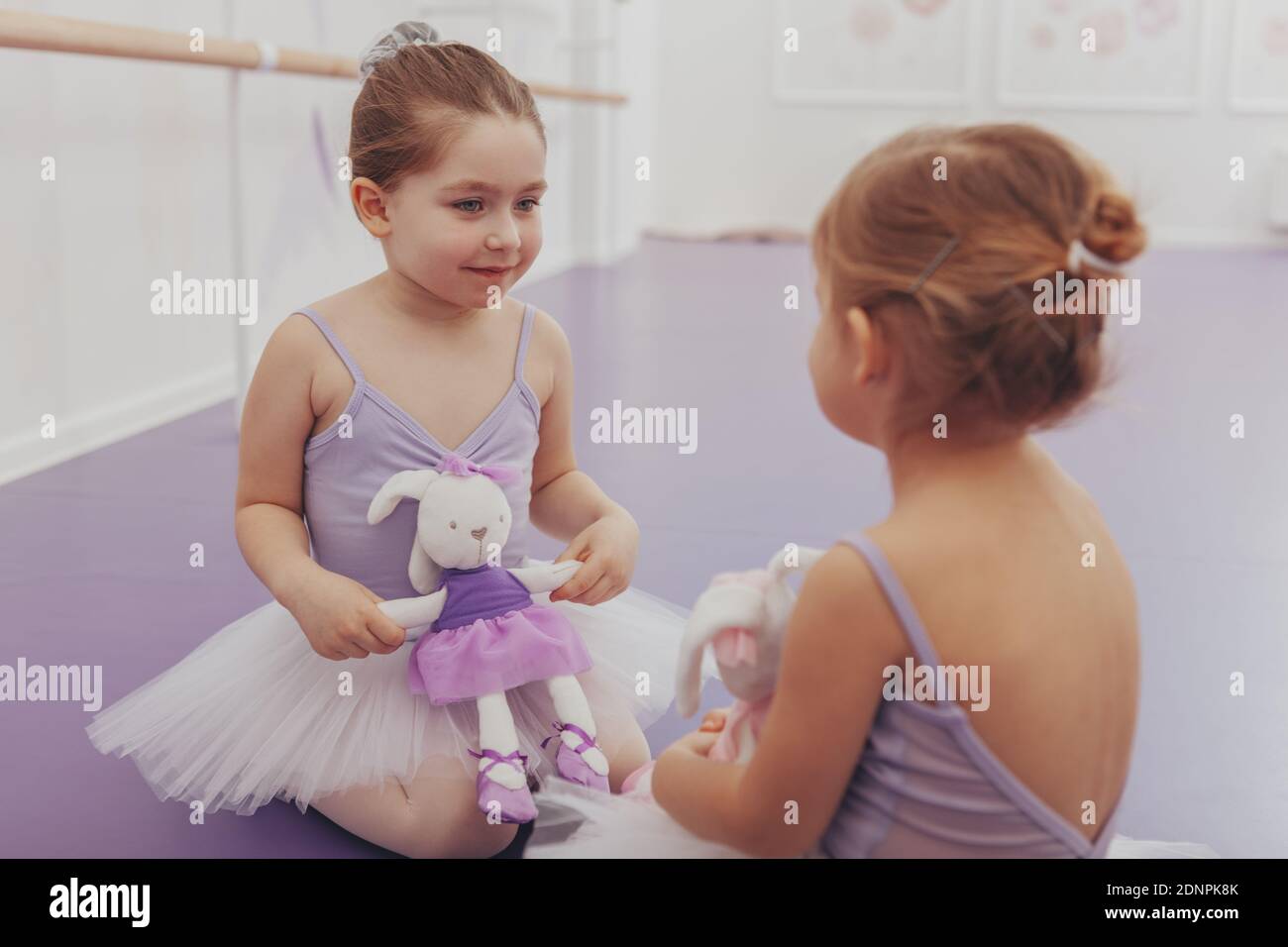 Adorable little ballerinas chatting at dance school during. Beautiful ...