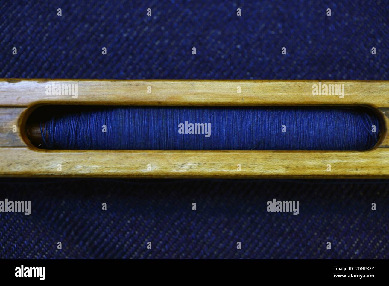Vintage weaving loom shuttle with blue thread on denim Stock Photo - Alamy