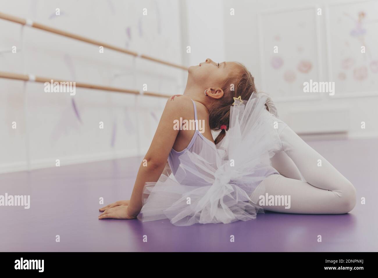 Adorable little ballerina exercising at ballet school. Cute young girl ...