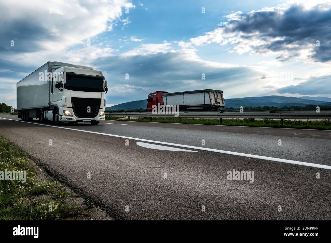 Highway scene - White semi trailer lorry truck passing another truck on ...